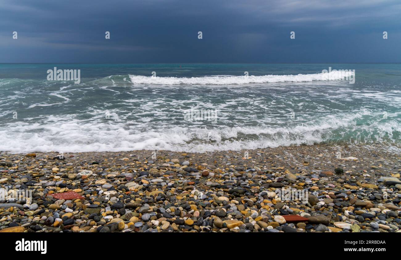 Dynamic Coastal Scene: Small Multi-Coloured Stones Awash with Foamy ...