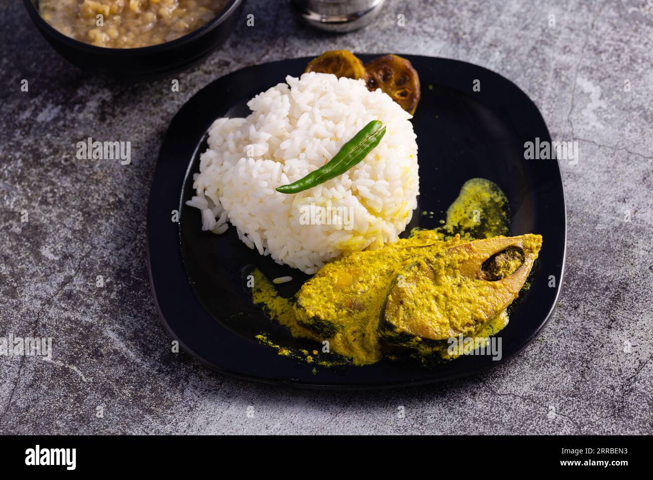 Top view of hilsa fish curry with mustard paste and green chilli served ...