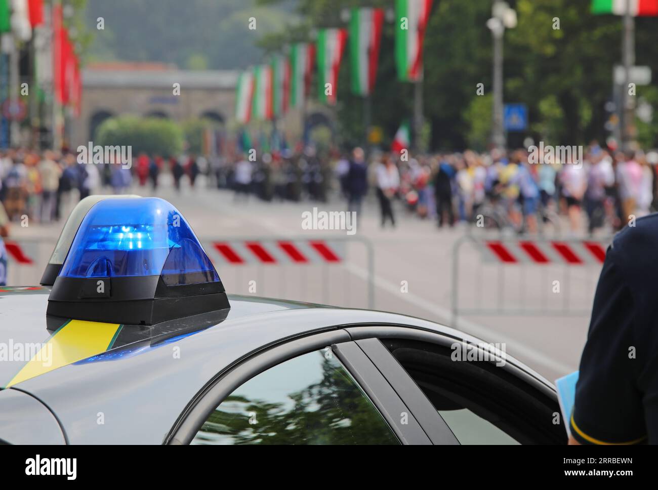 blue flashing police car and white red green flags during the ceremony ...