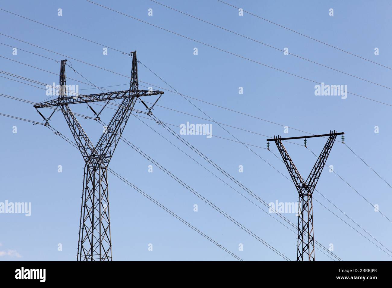 Electricity line and pylons. Blue bright sky Stock Photo - Alamy