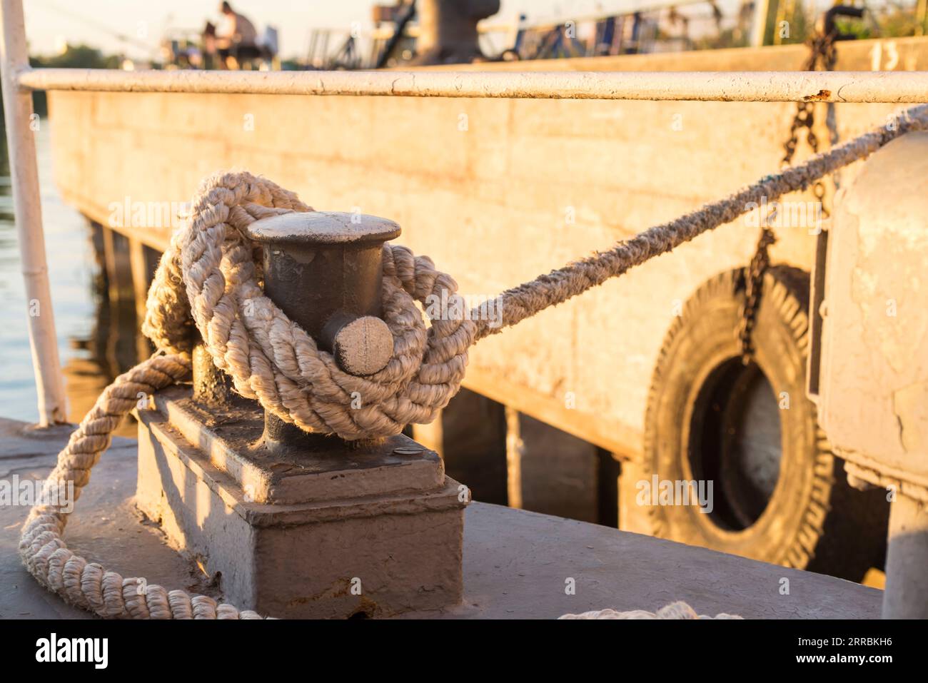 Tied rope knot on metallic bollard seafaring port. Nautical ship moored ...