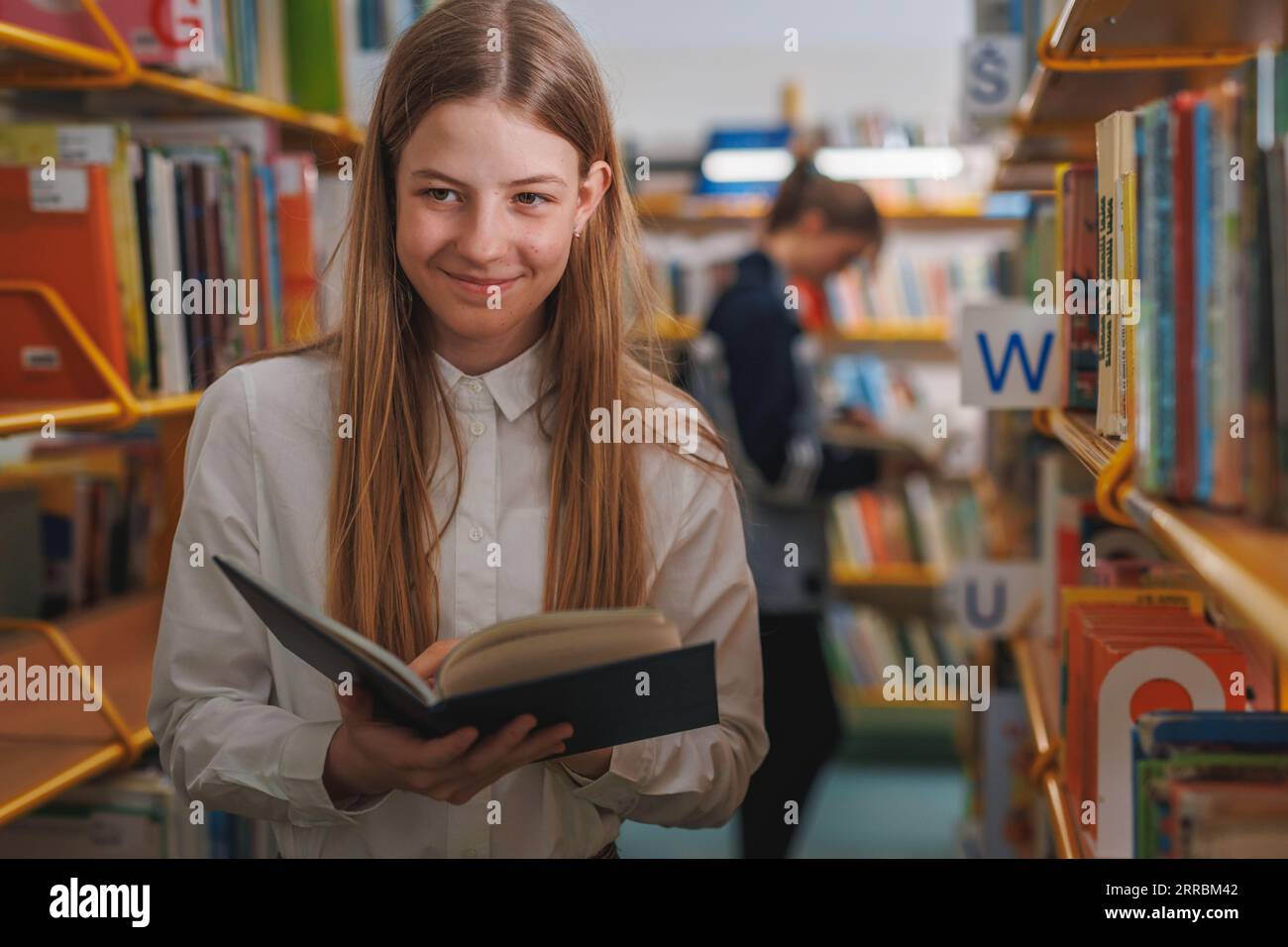 Curious female high school student inside the library, randomly picking ...