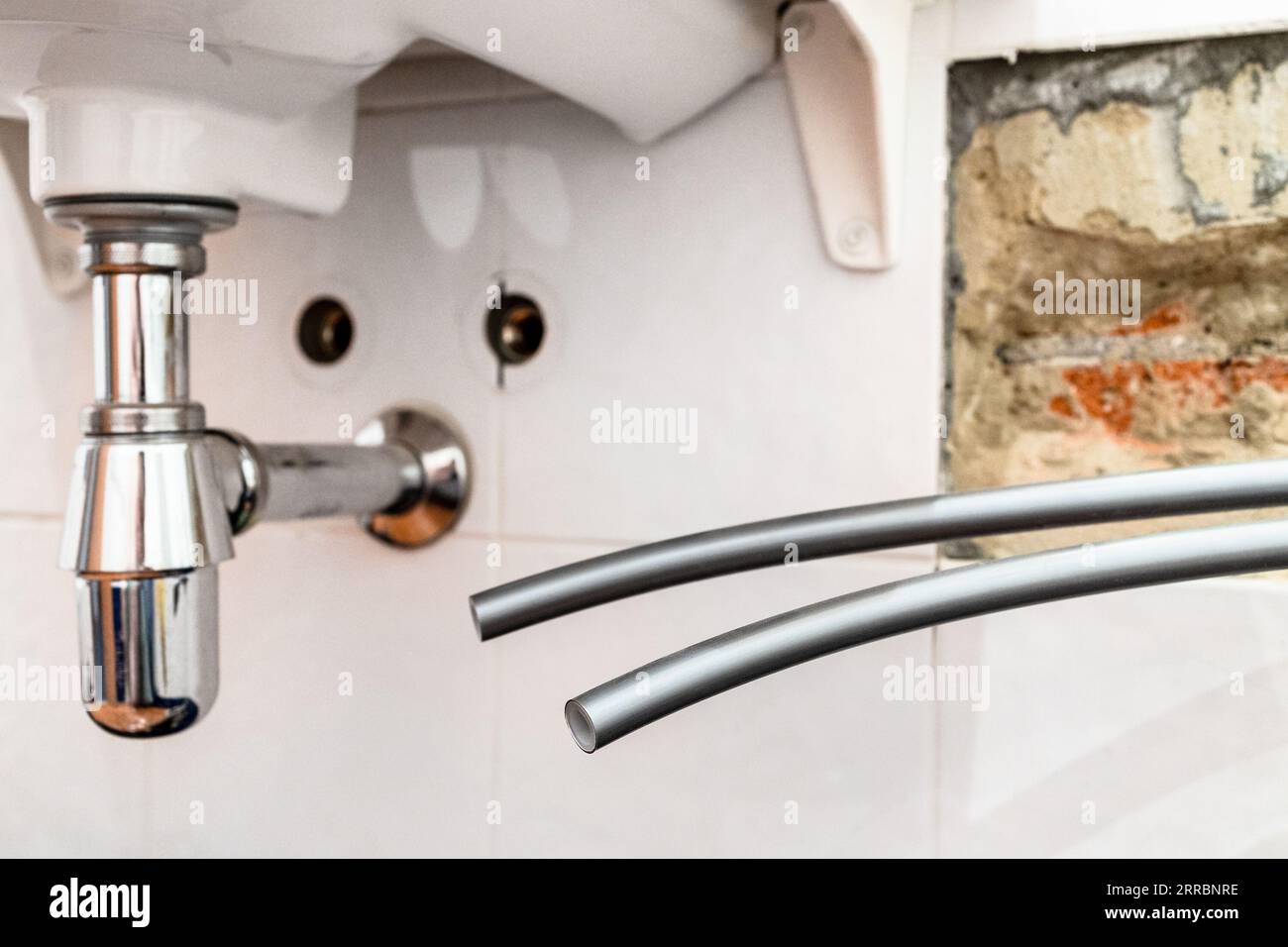 laying of new polyethylene flexible water pipes to faucet on sink ...