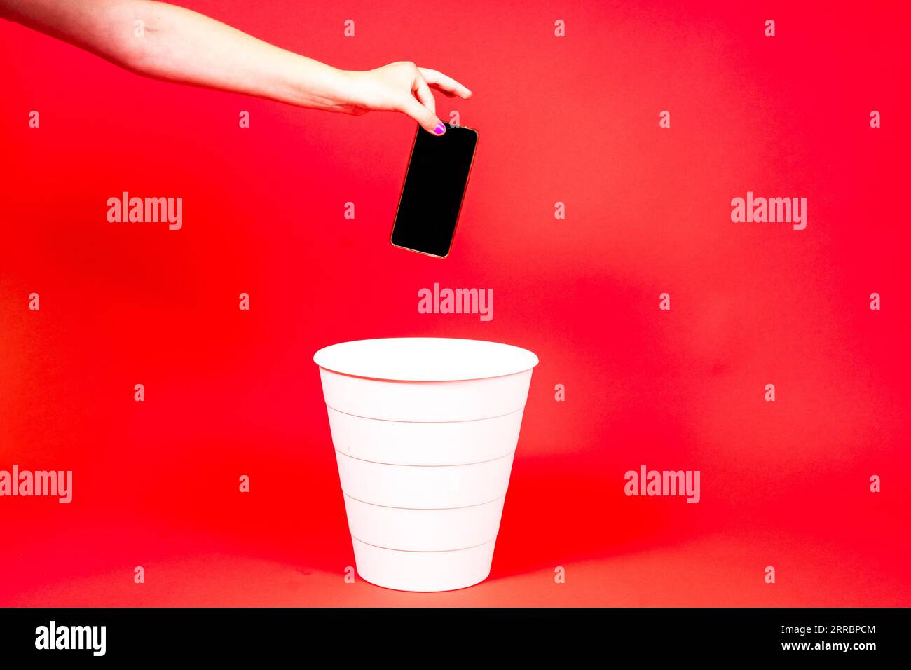 The smartphone is thrown into the trash for disposal and recycling ...