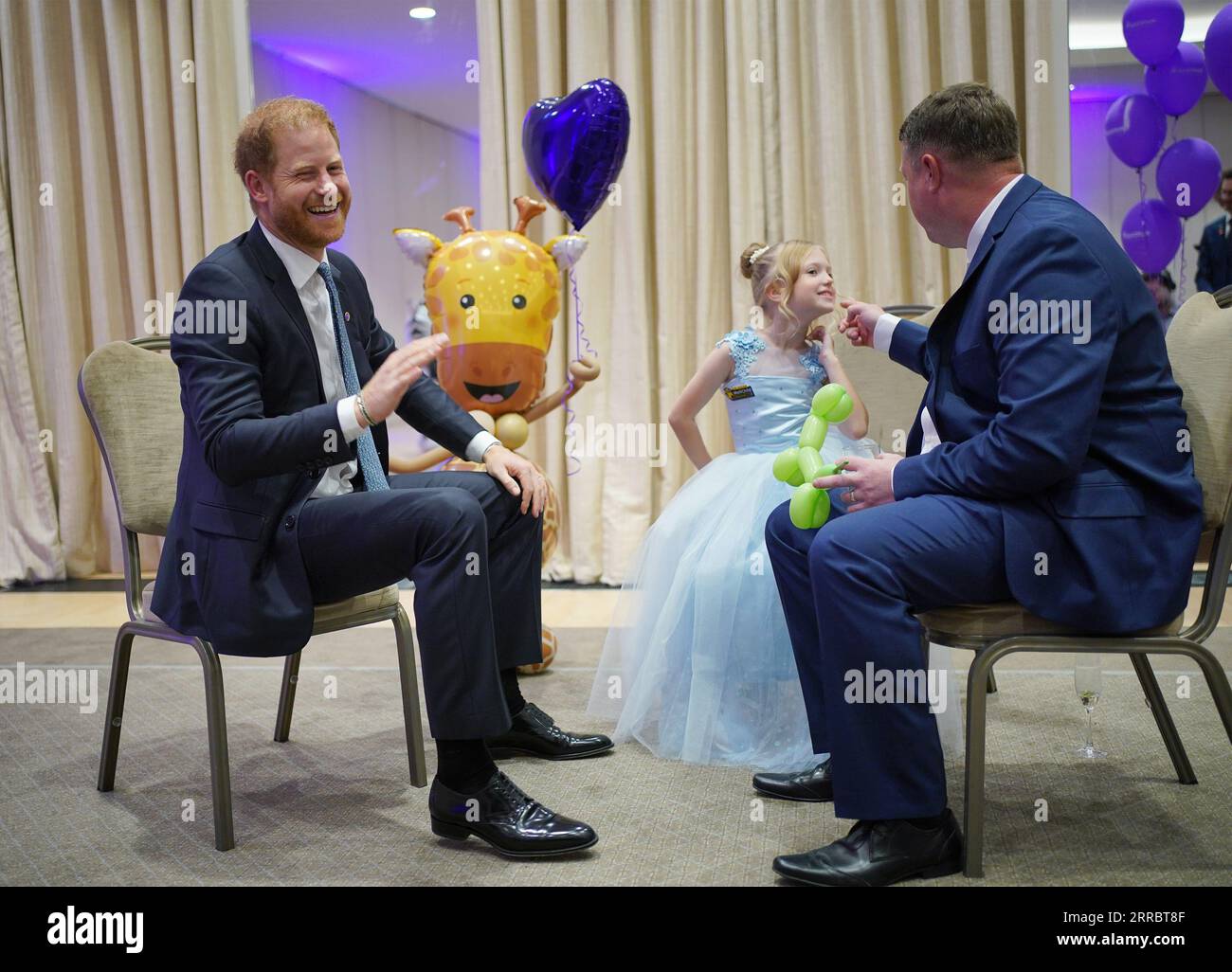 The Duke of Sussex speaks to Poppy and her father Daniel Higham, during ...
