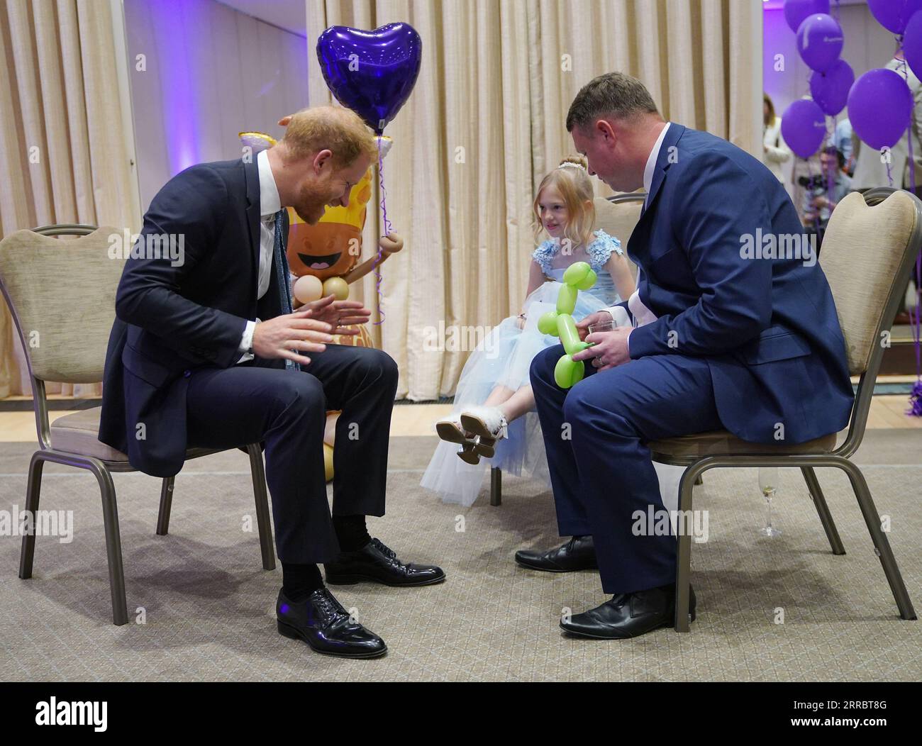The Duke of Sussex speaks to Poppy and her father Daniel Higham, during ...