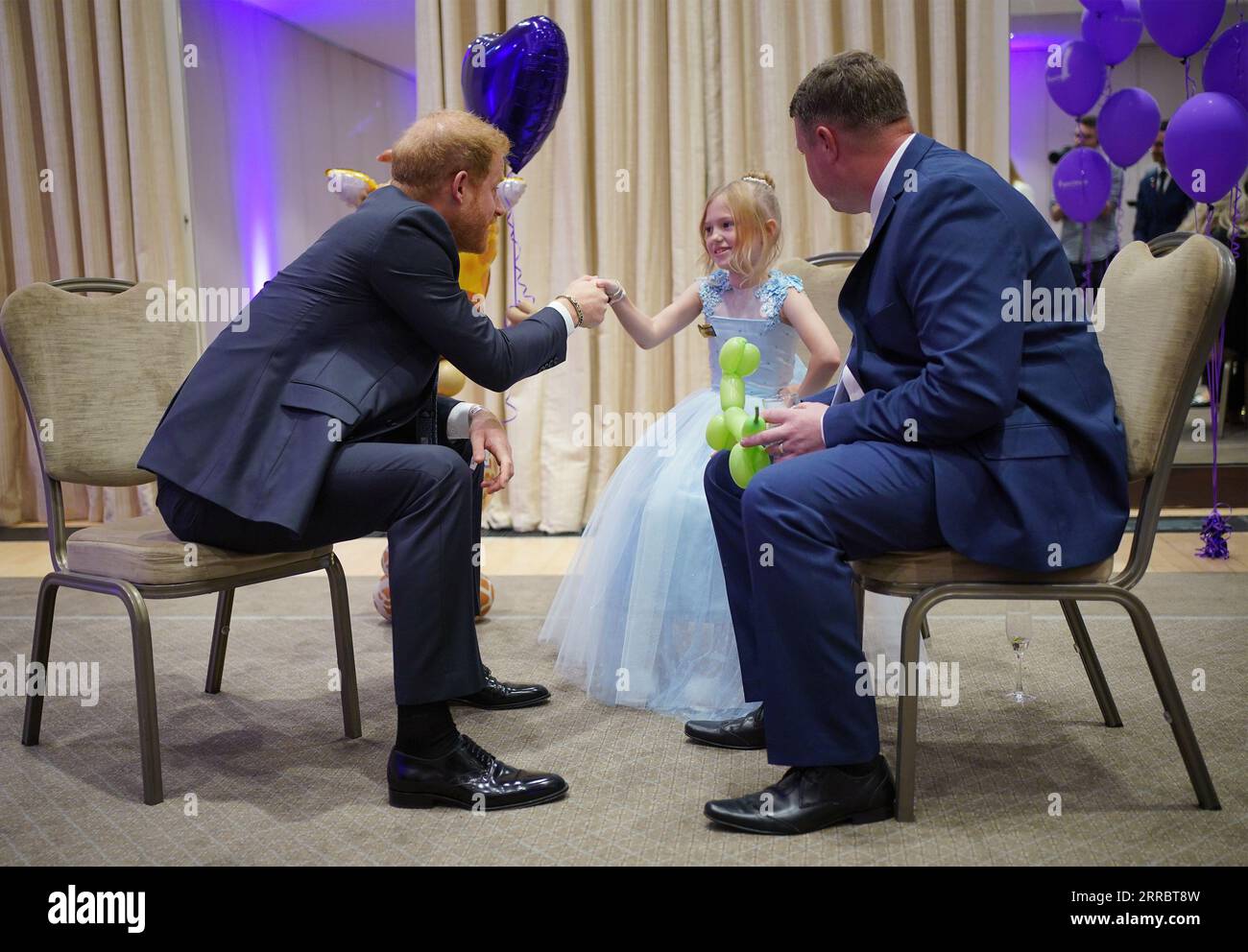 The Duke of Sussex speaks to Poppy and her father Daniel Higham, during ...