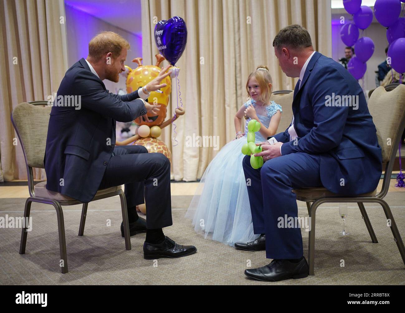 The Duke of Sussex speaks to Poppy and her father Daniel Higham, during ...