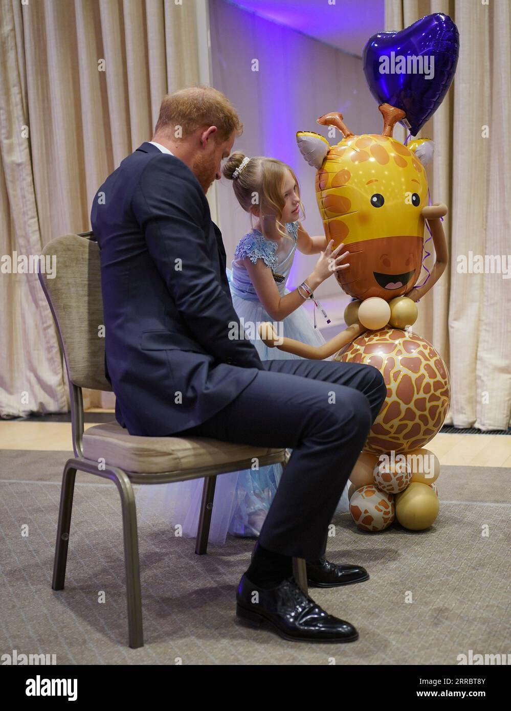 The Duke of Sussex speaks to Poppy and her father Daniel Higham, during ...