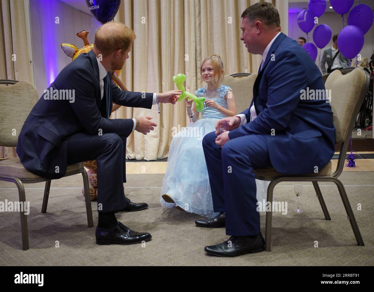 The Duke of Sussex speaks to Poppy and her father Daniel Higham, during ...