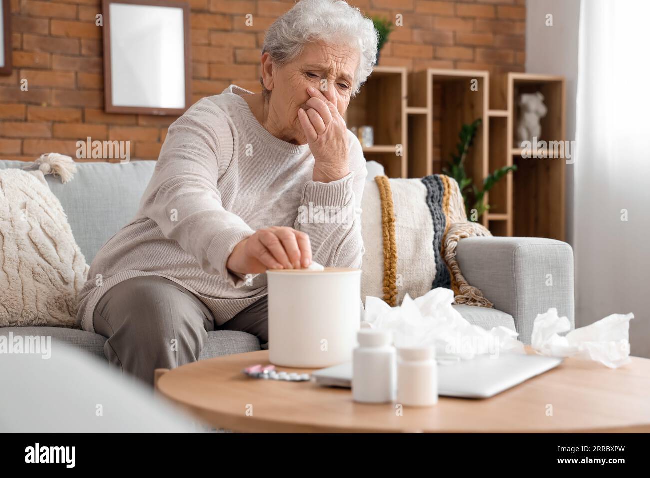 Ill senior woman taking tissue at home Stock Photo - Alamy