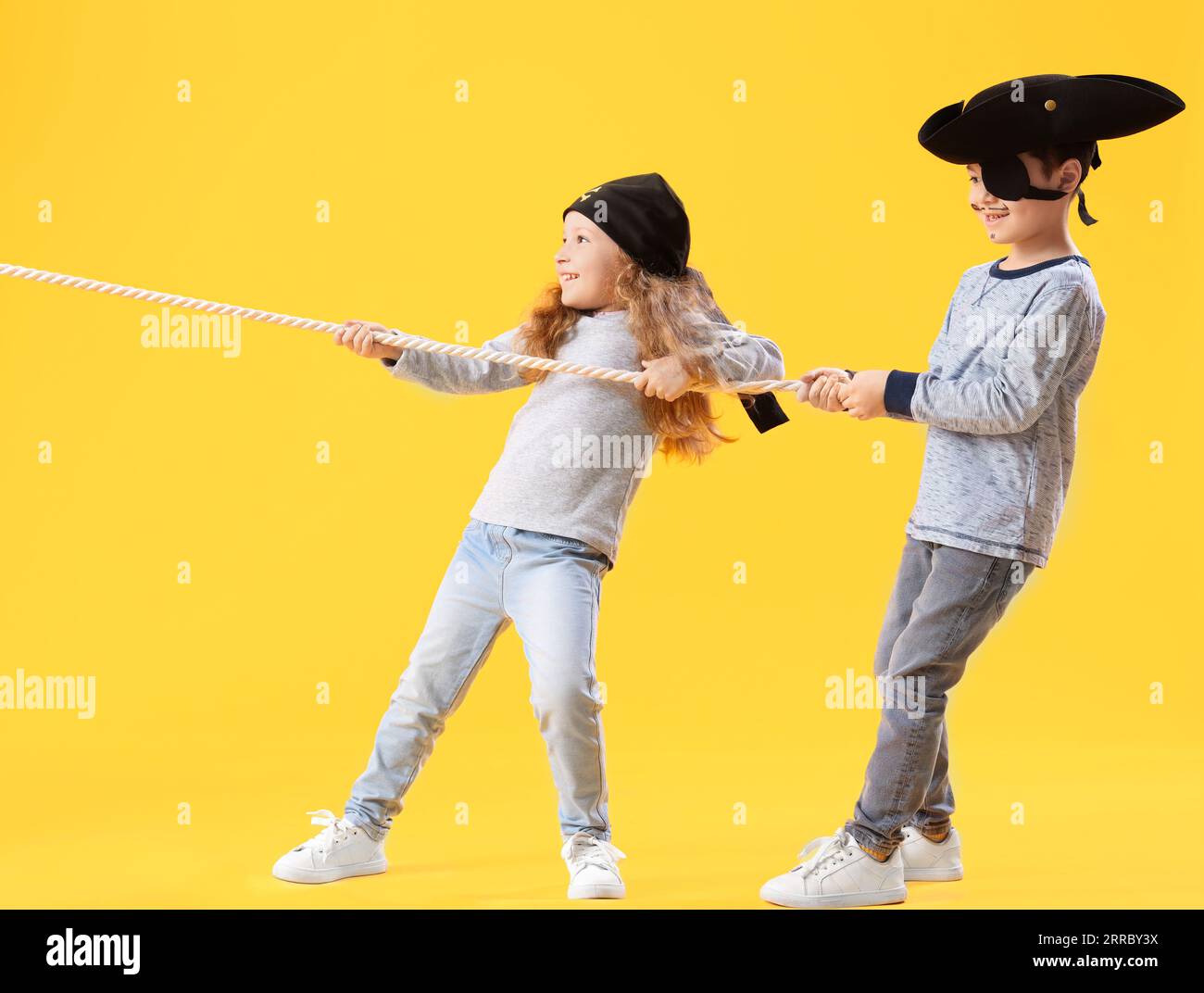 Cute little pirates with rope on yellow background Stock Photo - Alamy