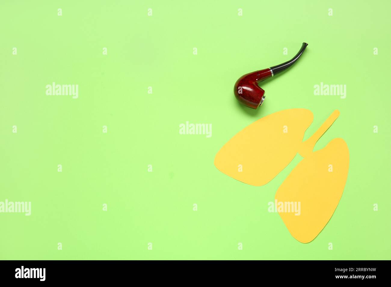 Paper lungs and smoking pipe on green background. Lung cancer concept ...