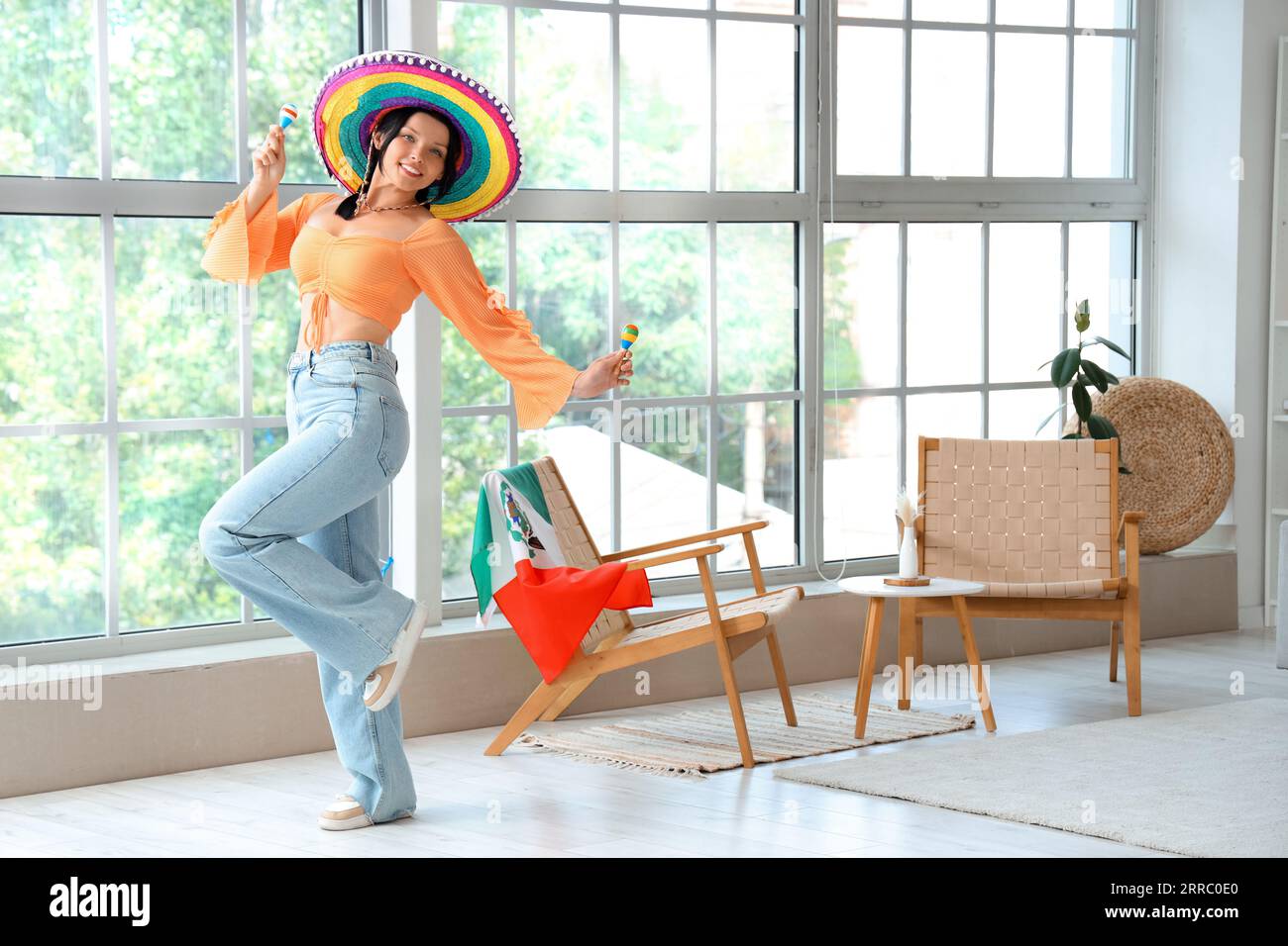Young Mexican woman in sombrero hat with maracas dancing at home Stock ...