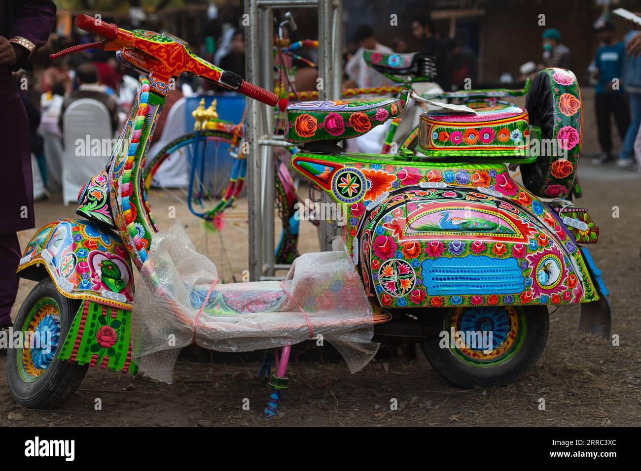 A motorcycle decorated in traditional Pakistani truck art, parked on a ...