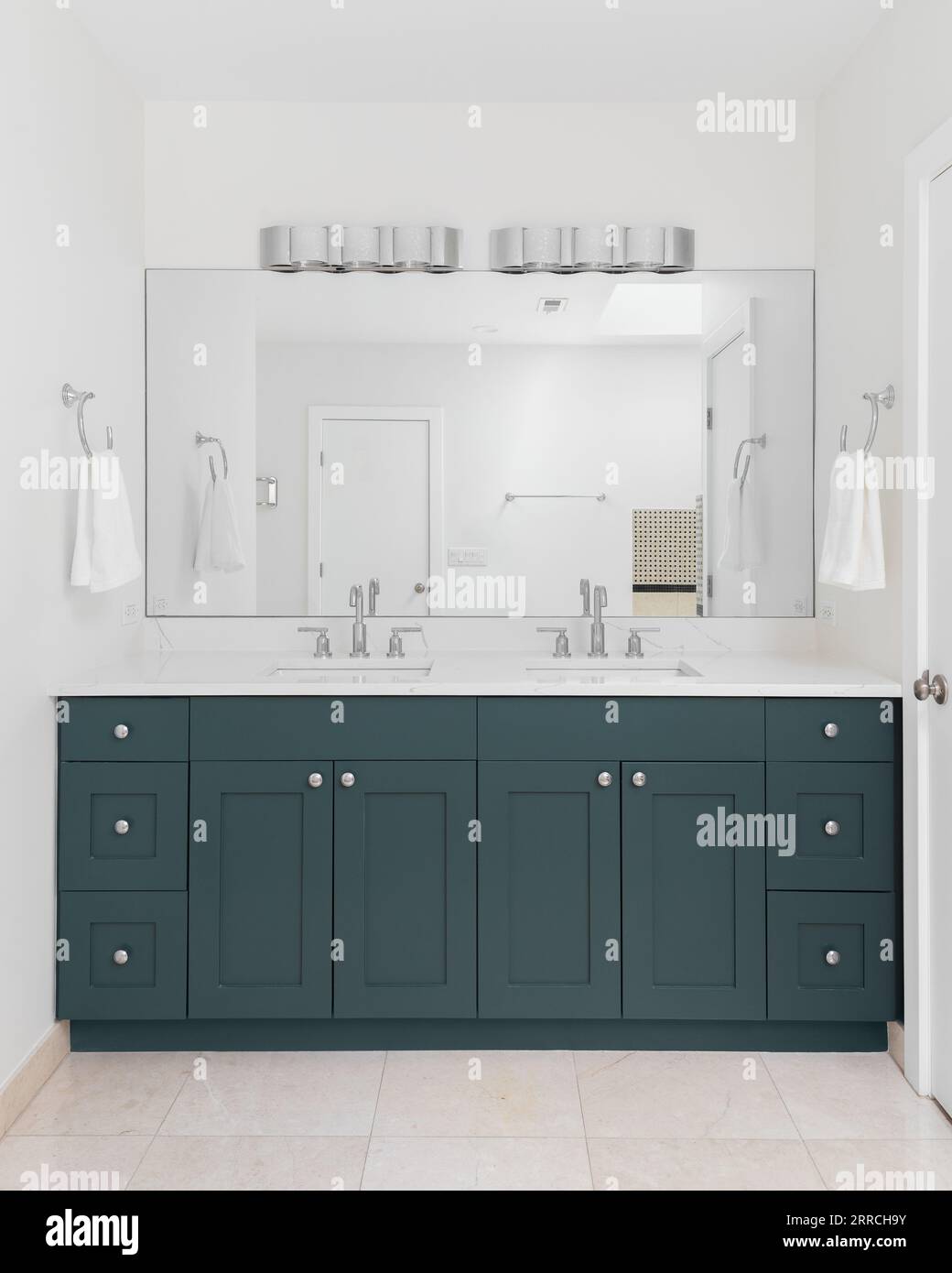 A bathroom with a blue green vanity cabinet, white marble countertop ...