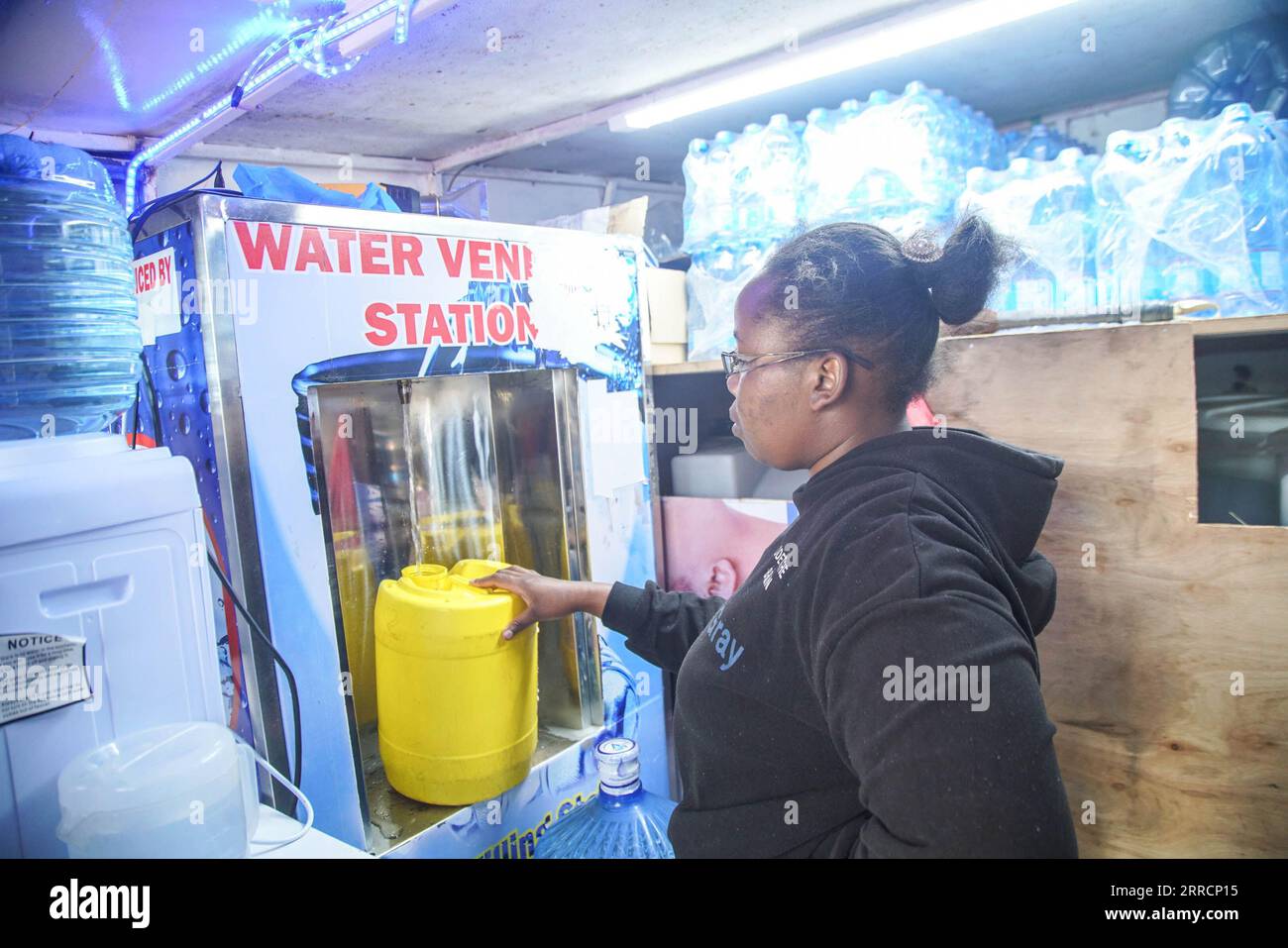 An attendant is seen refilling the water bottle at the refill station ...