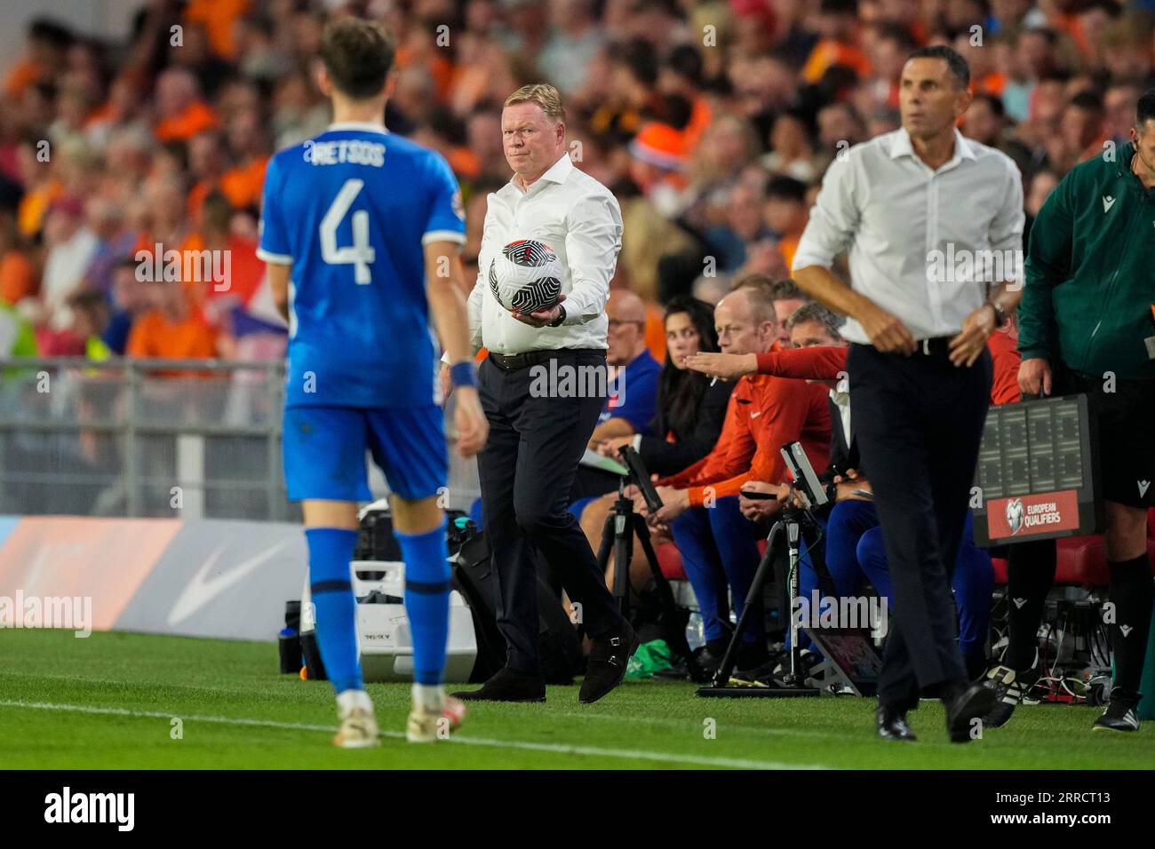Netherlands' head coach Ronald Koeman holds the ball near Greece's head ...