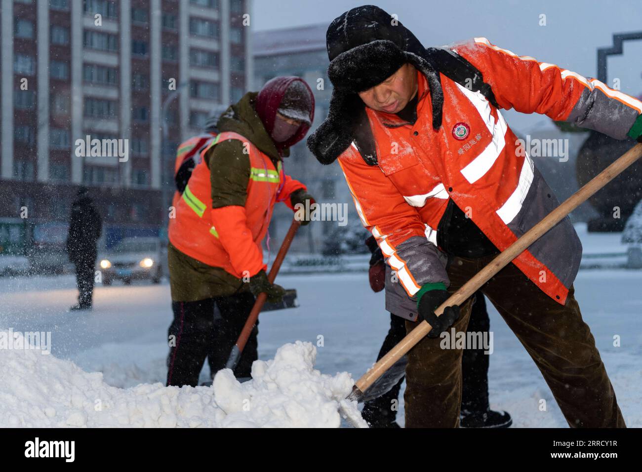 211122 -- HEGANG, Nov. 22, 2021 -- Sanitation workers clear snow from a ...