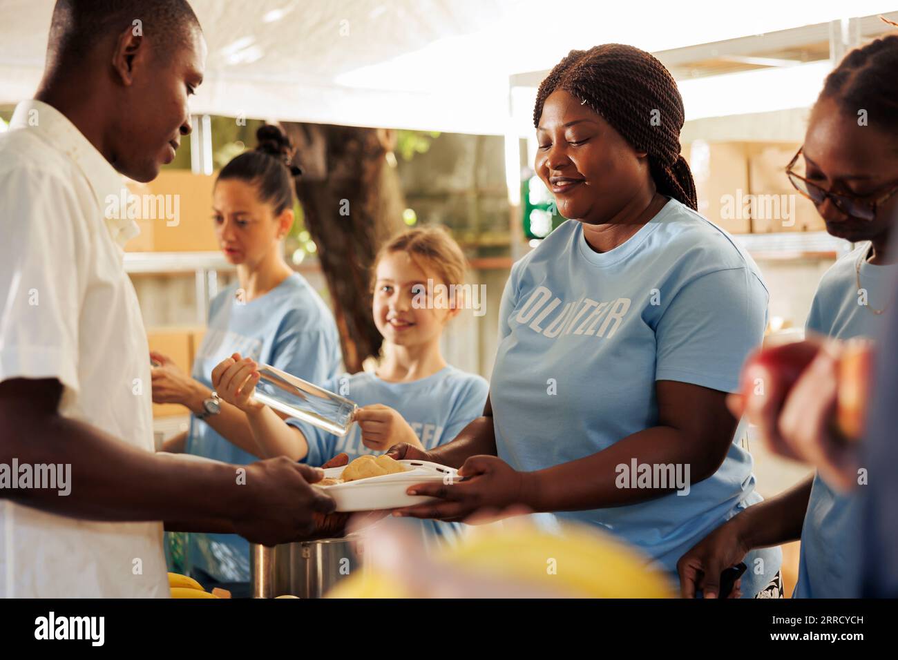 Women of different ethnicities volunteering at local food bank serving ...