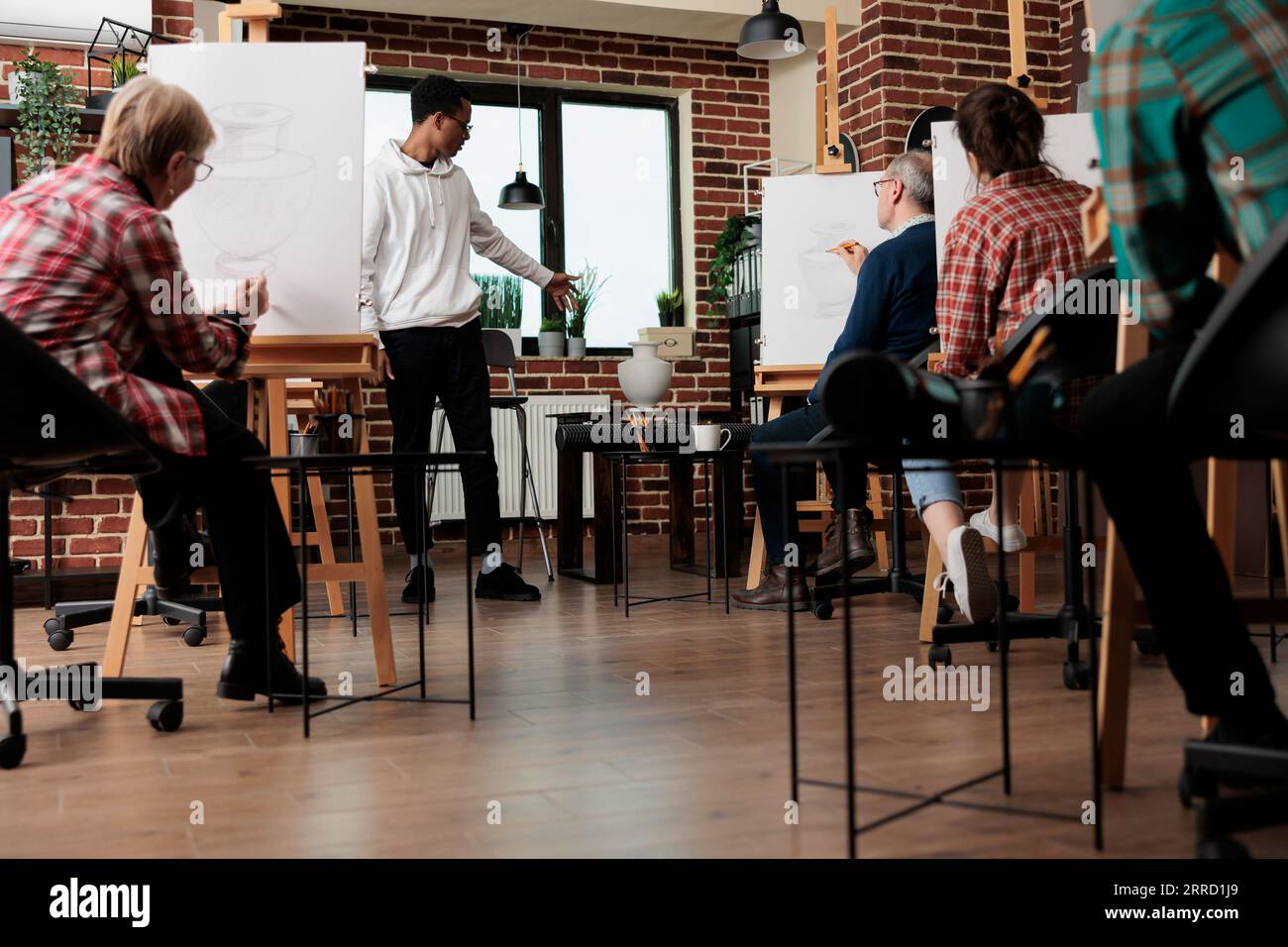 Group of people drawing with pencils on canvas, attending art class ...