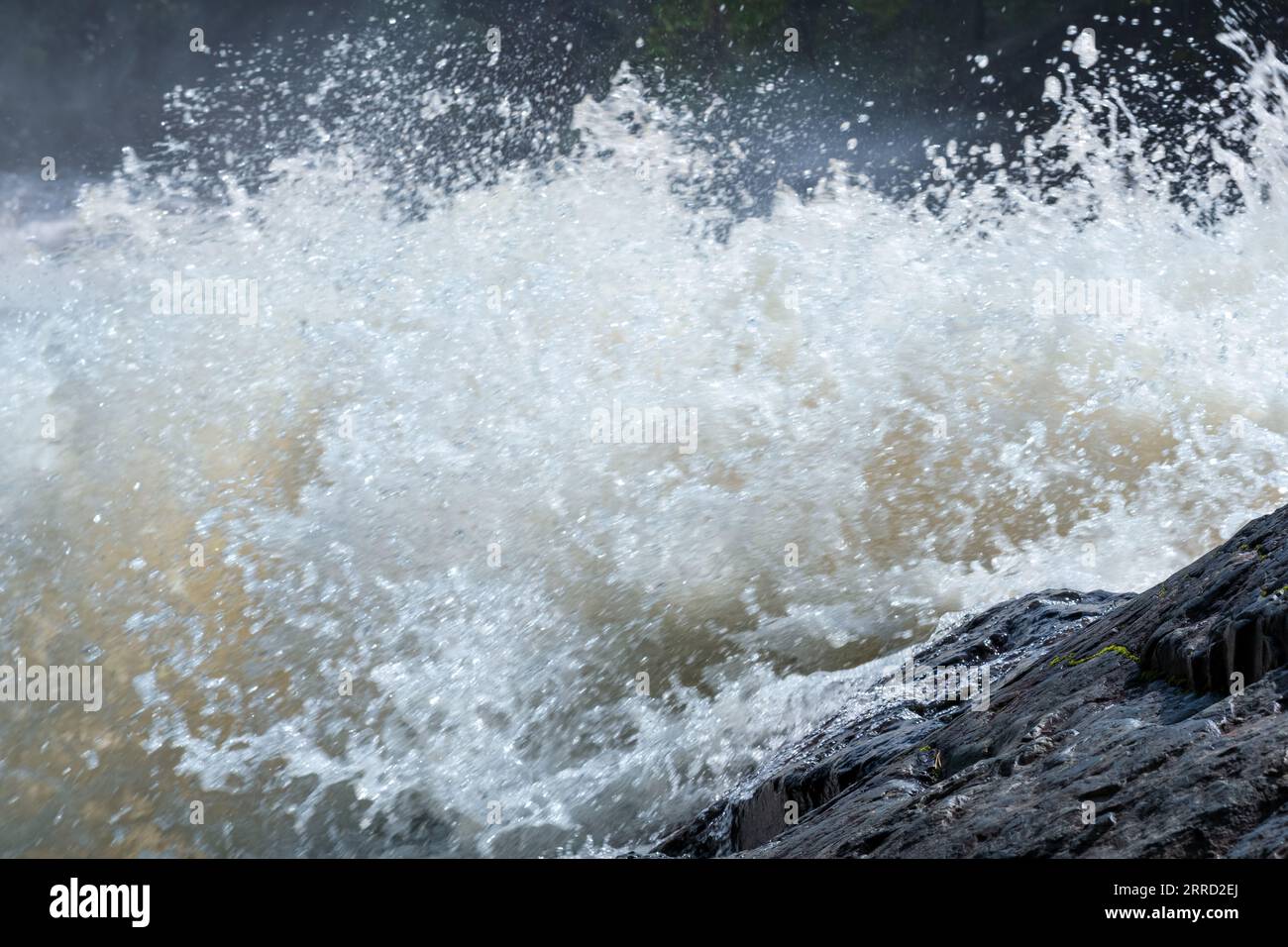 muddy turbulent stream under a rock during high water Stock Photo - Alamy