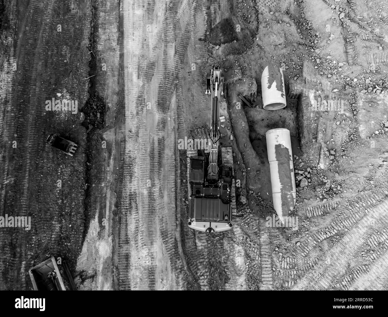 Excavator next to an open trench with two culverts ready for a ...