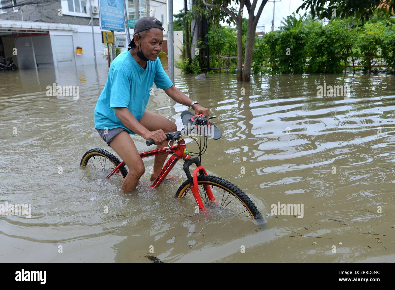 Man rides bicycle in rain hi-res stock photography and images - Alamy