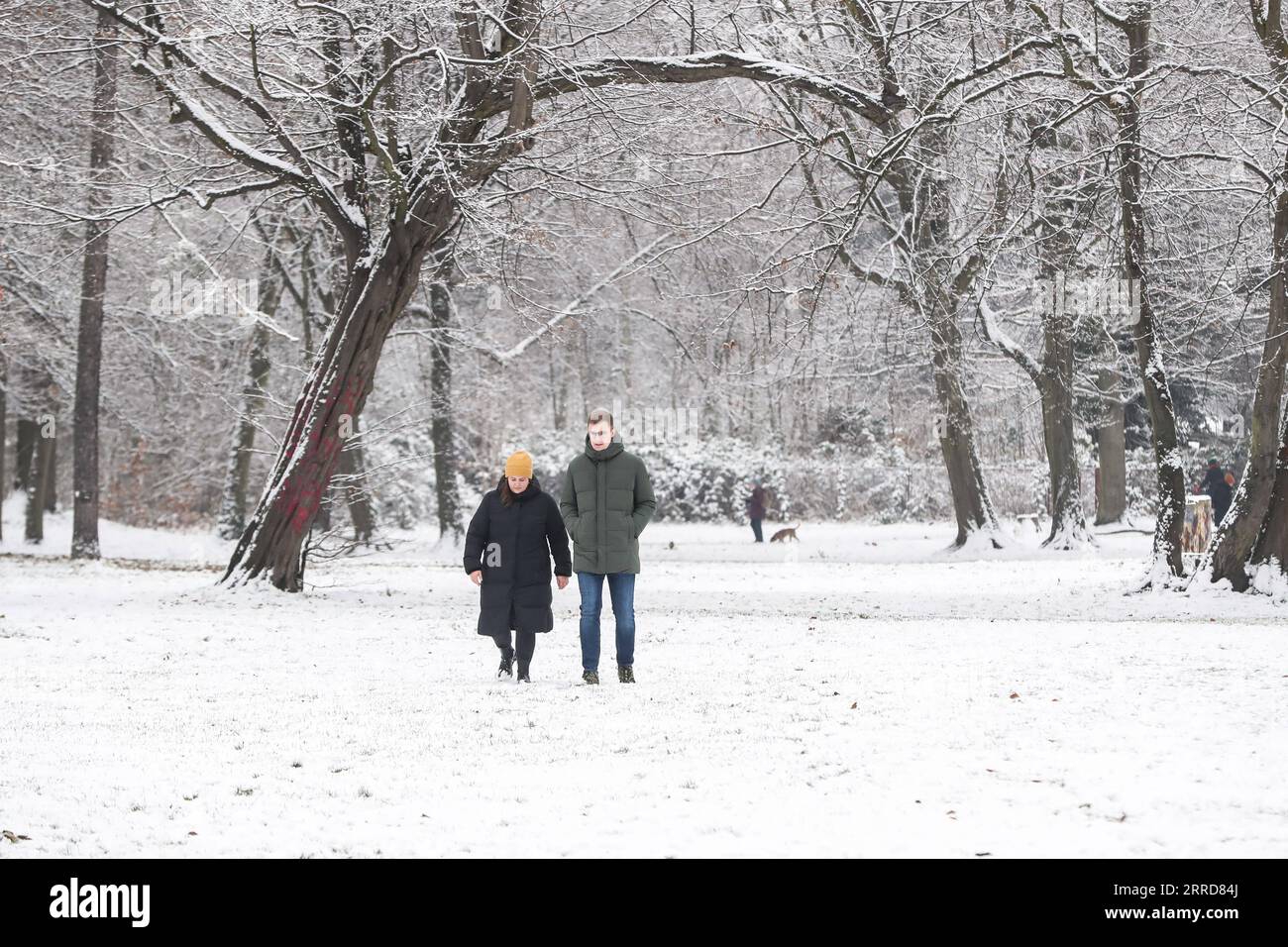 211209 -- BERLIN, Dec. 9, 2021 -- Pedestrians walk at a snow-covered ...