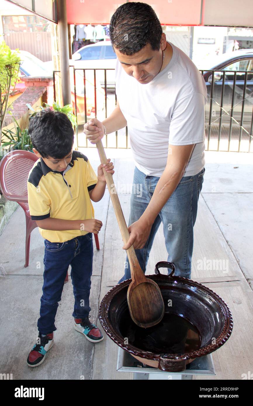 Latin dad and son cook together the traditional Mexican dish mole rojo ...