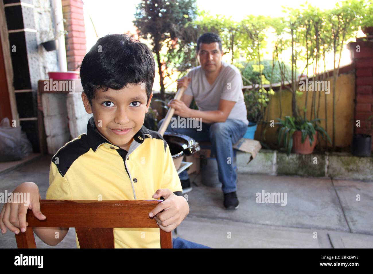 Latin dad and son cook together the traditional Mexican dish mole rojo ...