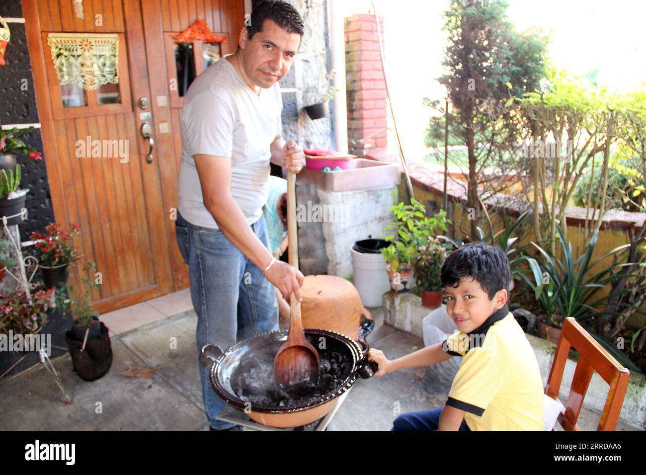 Latin dad and son cook together the traditional Mexican dish mole rojo ...
