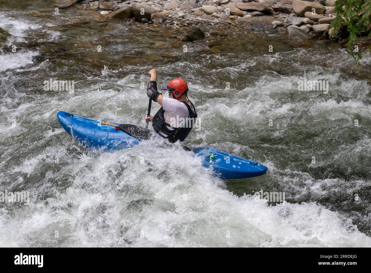 Bearded male kayaker takes advantage of the swollen river from heavy ...