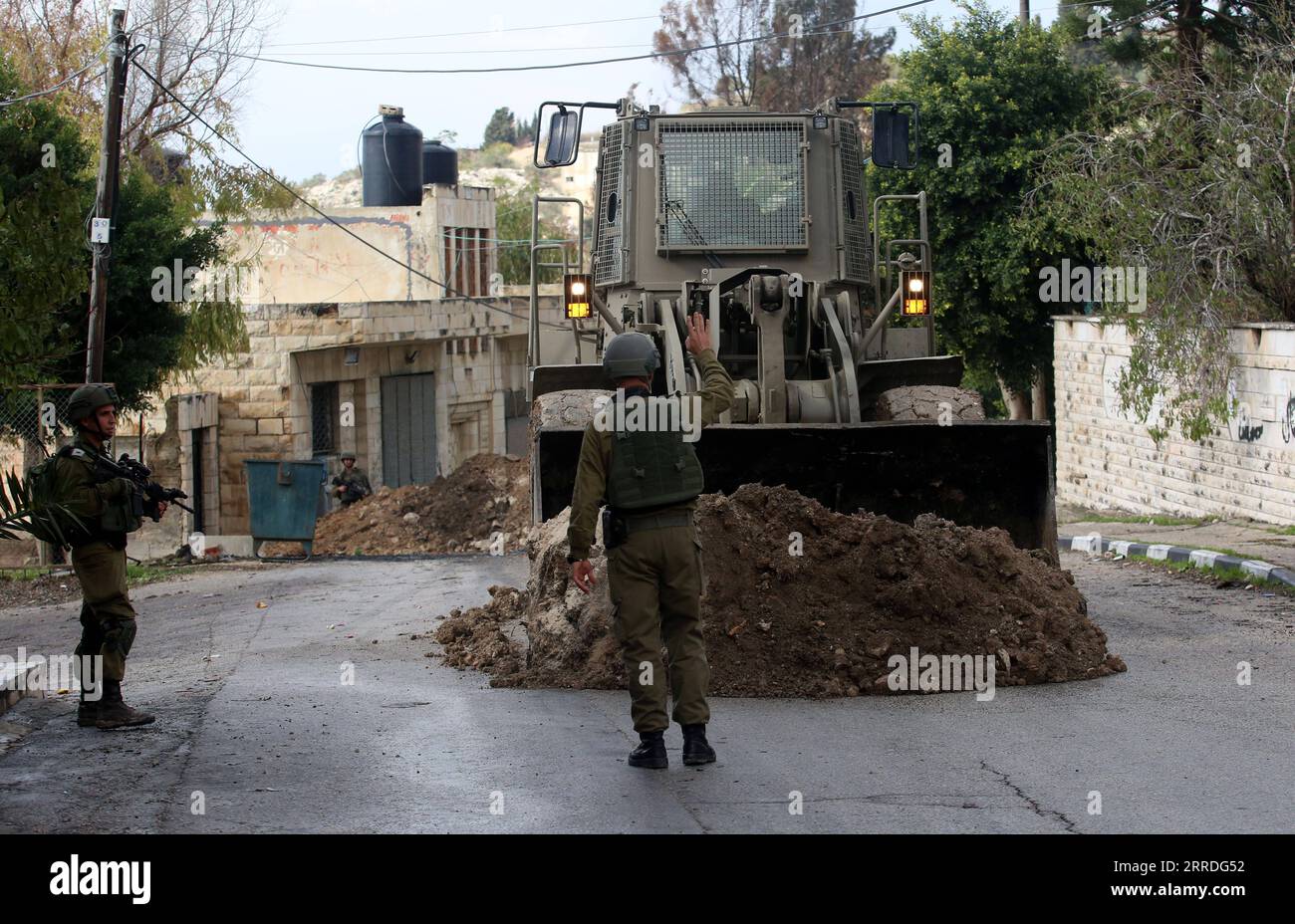211223 -- NABLUS, Dec. 23, 2021 -- Israeli soldiers and a bulldozer are ...