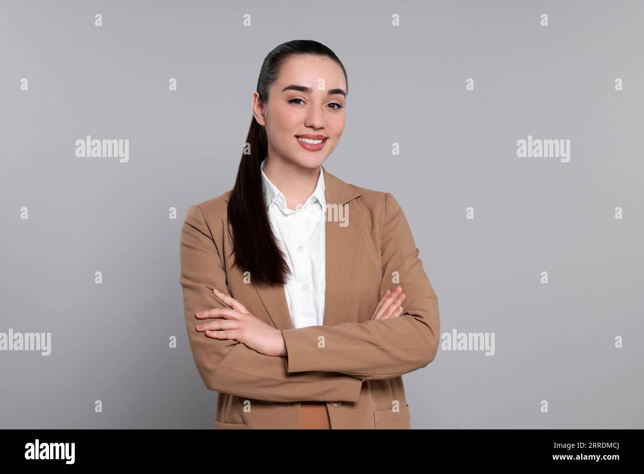 Happy real estate agent on grey background Stock Photo - Alamy