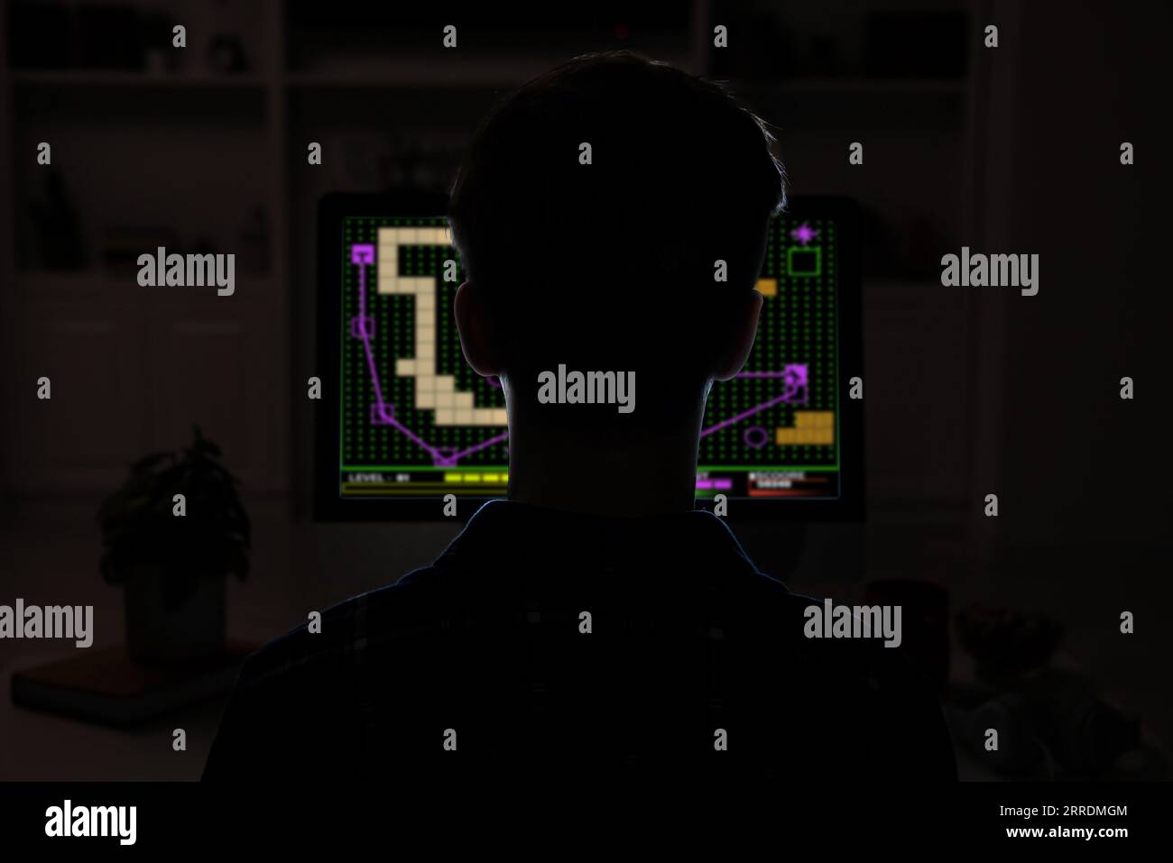 Gaming disorder. Teenager playing on computer in darkness, back view ...