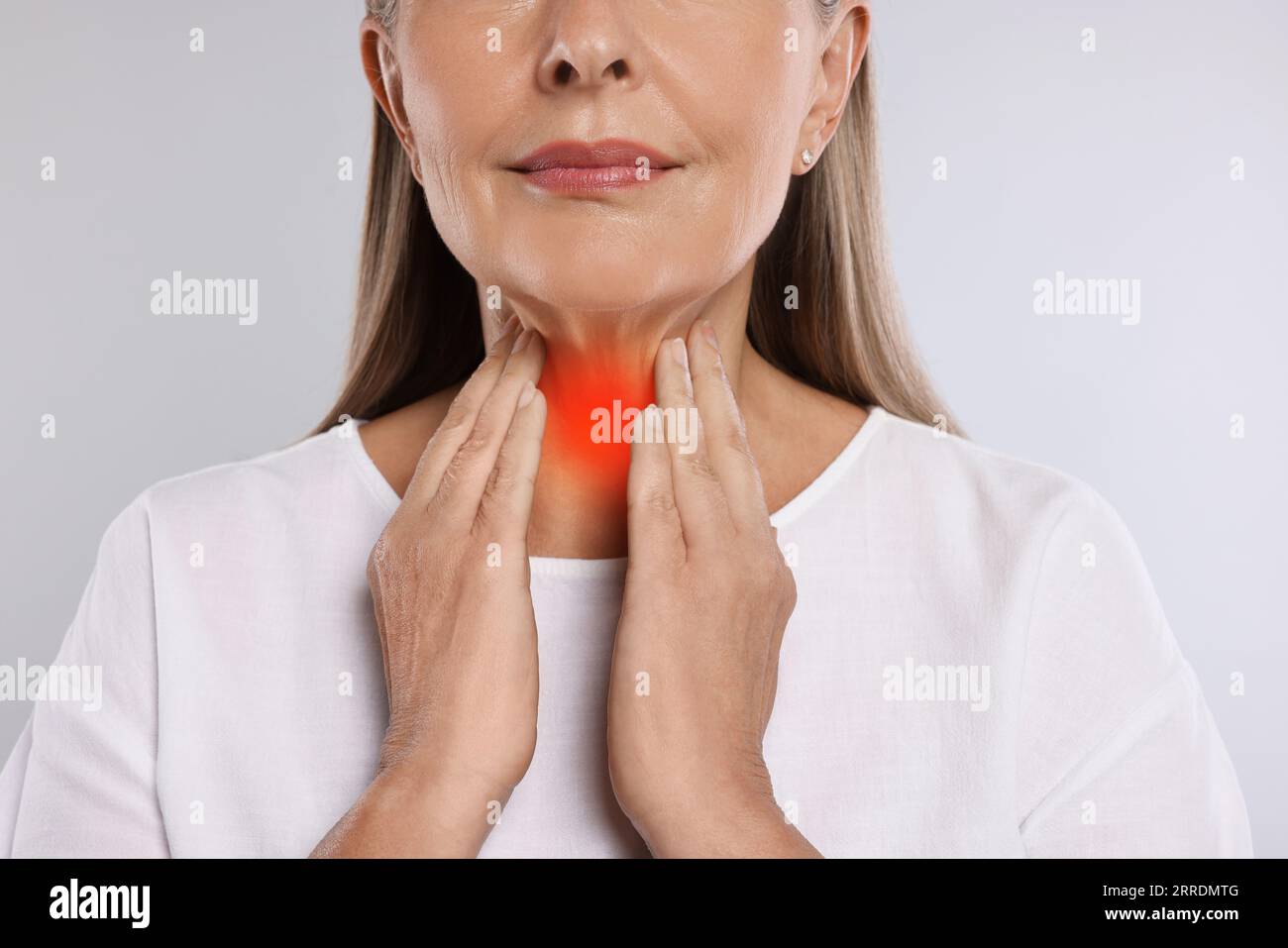 Endocrine system. Woman doing thyroid self examination on light grey ...