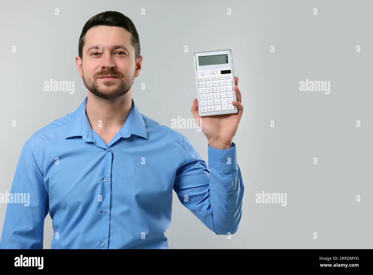 Accountant showing calculator on light grey background. Space for text ...
