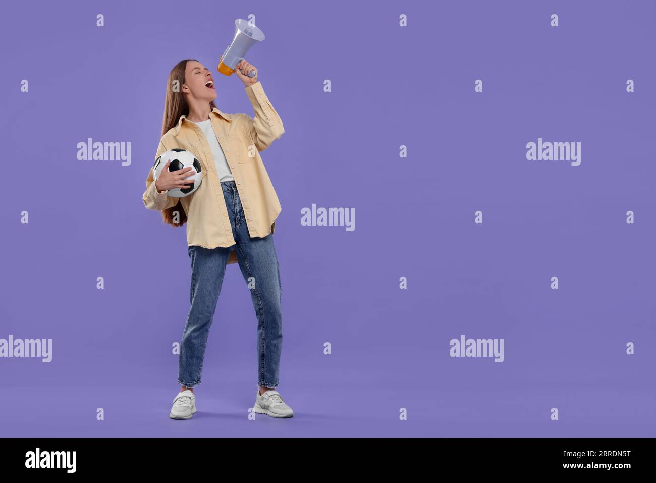 Emotional sports fan with ball and megaphone on purple background ...