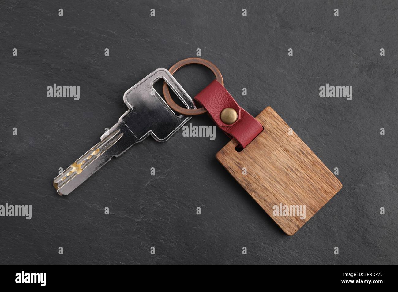 Key and wooden keychain with Ukrainian coat of arms on grey background ...