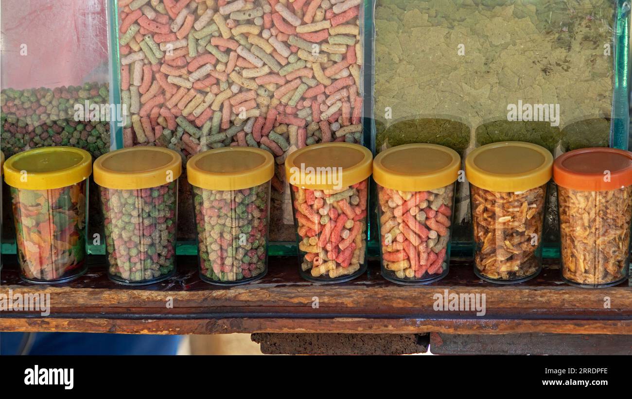 Fish food capsules in plastic boxes sold on a market stall Stock Photo ...