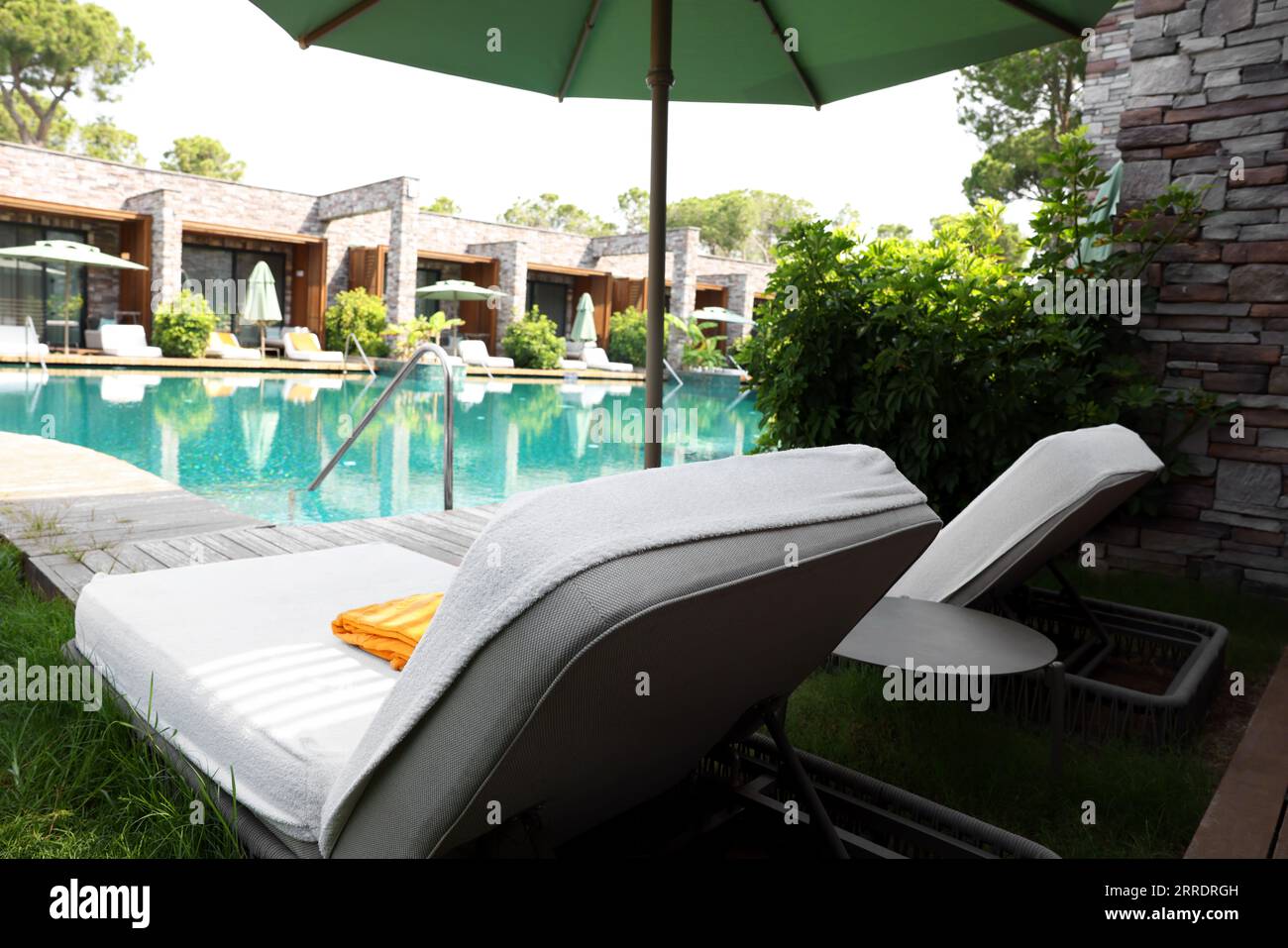 Sunbeds near outdoor swimming pool at luxury resort Stock Photo - Alamy