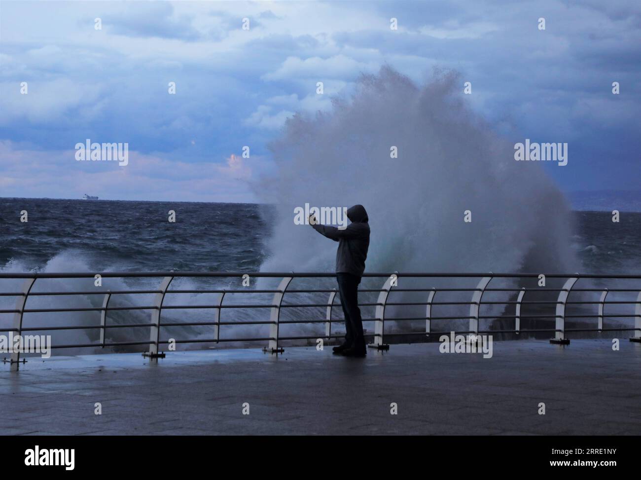 220119 -- BEIRUT, Jan. 19, 2022 -- A person takes photos of big waves ...