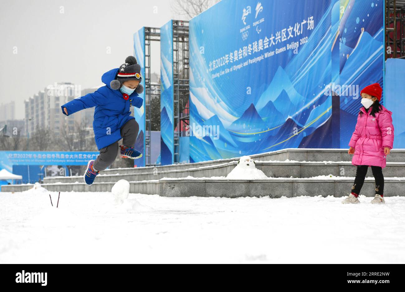 220122 -- BEIJING, Jan. 22, 2022 -- Children have fun amid snow at a park in Beijing, capital of ...