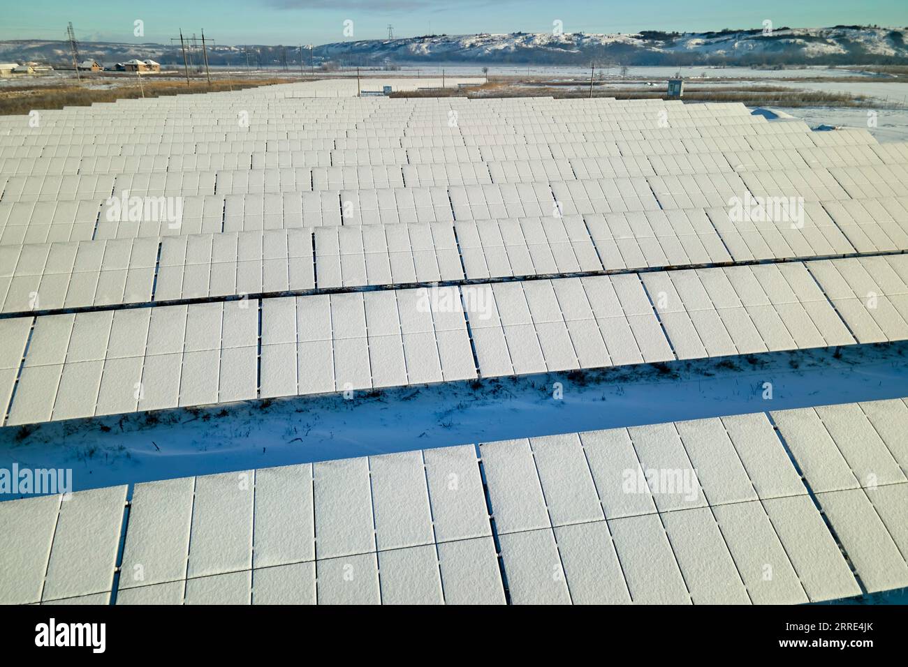 Aerial view of snow covered sustainable electric power plant with rows ...