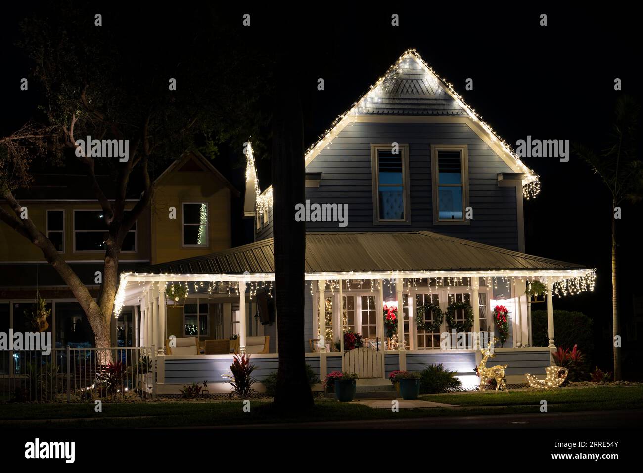 Brightly illuminated christmas decorations on front yard porch of ...