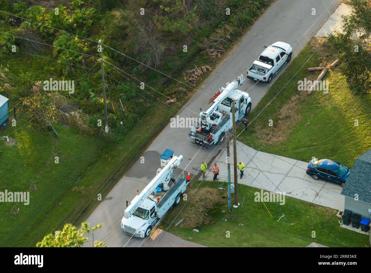 Electrician workers repairing damaged power lines using bucket trucks ...