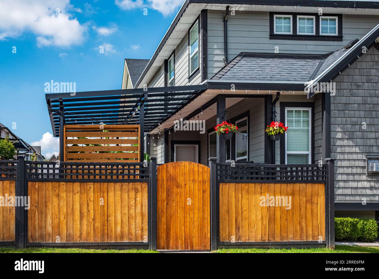 Nice new wooden fence around house. Wooden fence with green lawn in a ...