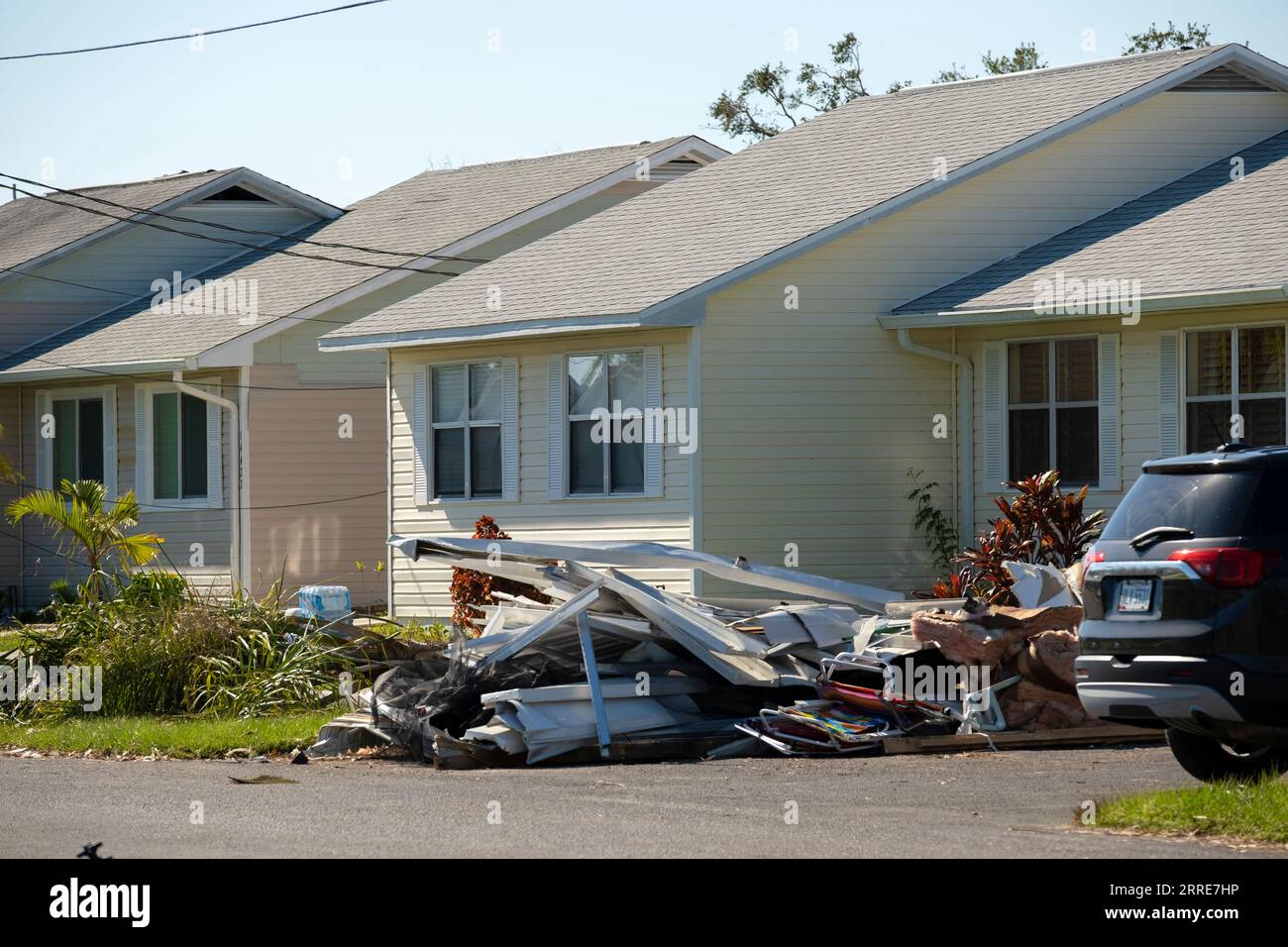 Scrap metal disposed in heaps on street side after hurricane severely ...