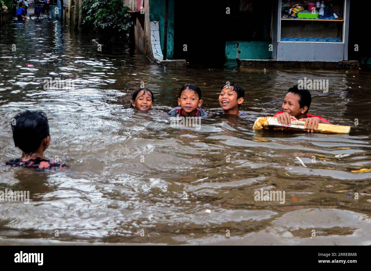 220217 -- BOGOR, Feb. 17, 2022 -- Children swim in the flood water ...